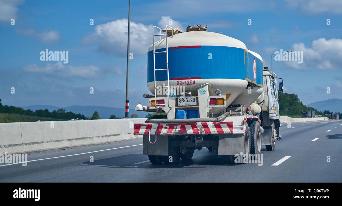 Blue colored cement truck on a highway under a blue sky with white ...