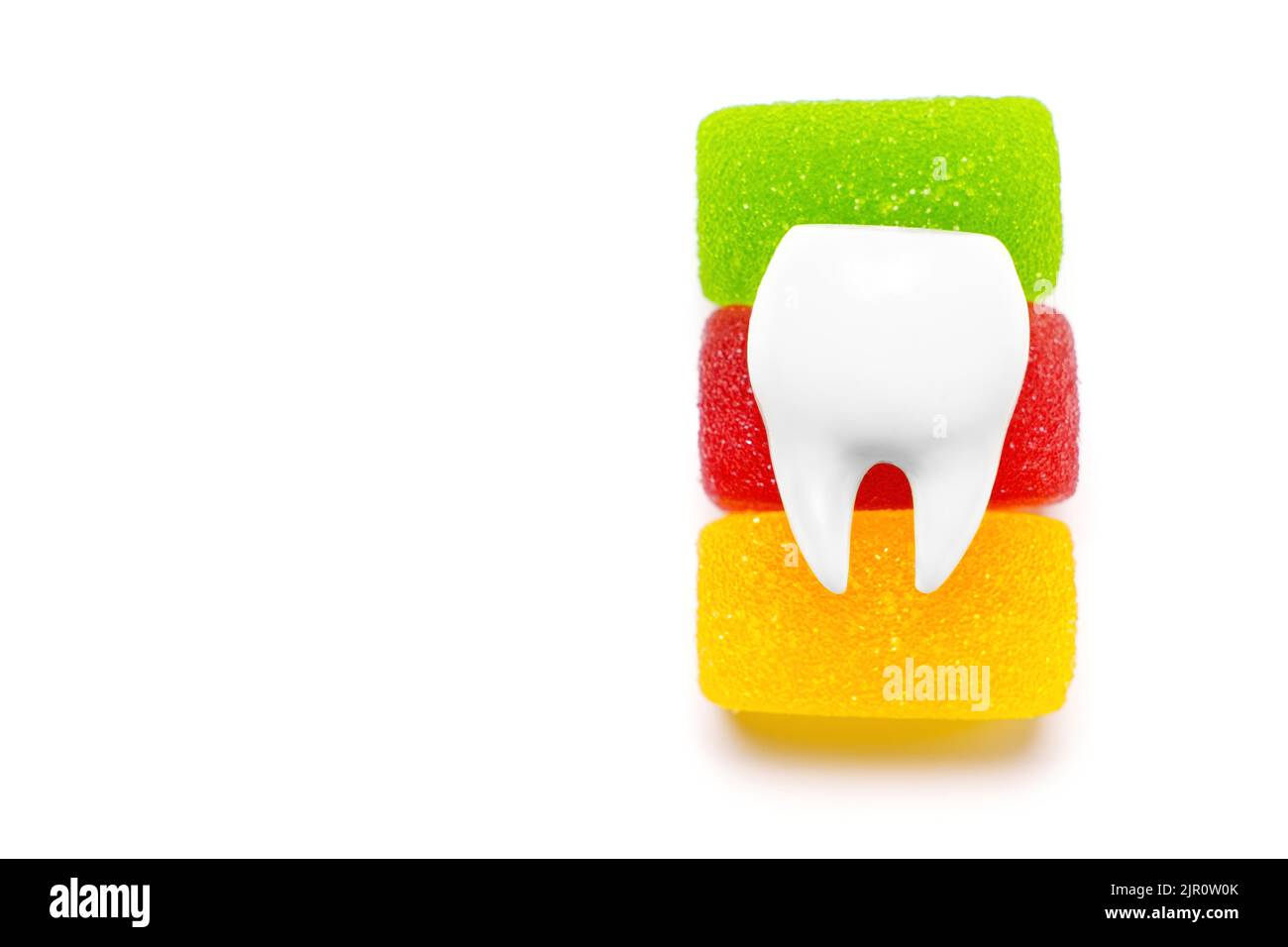 Large white tooth model placed on top of colorful jelly candies ...