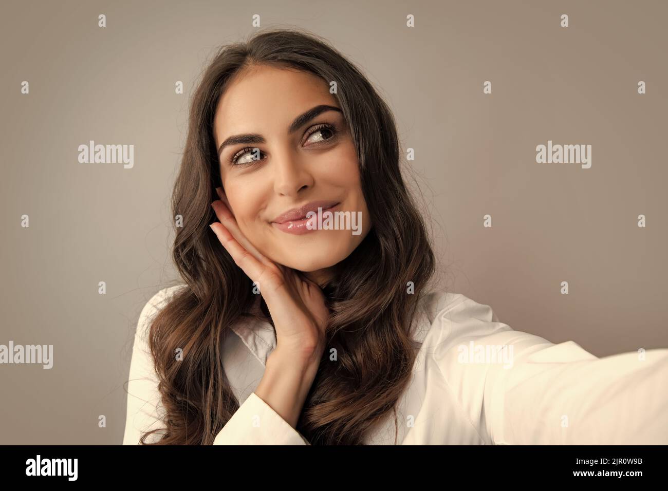 Pleasant girl making selfie in studio and laughing. Good-looking young ...