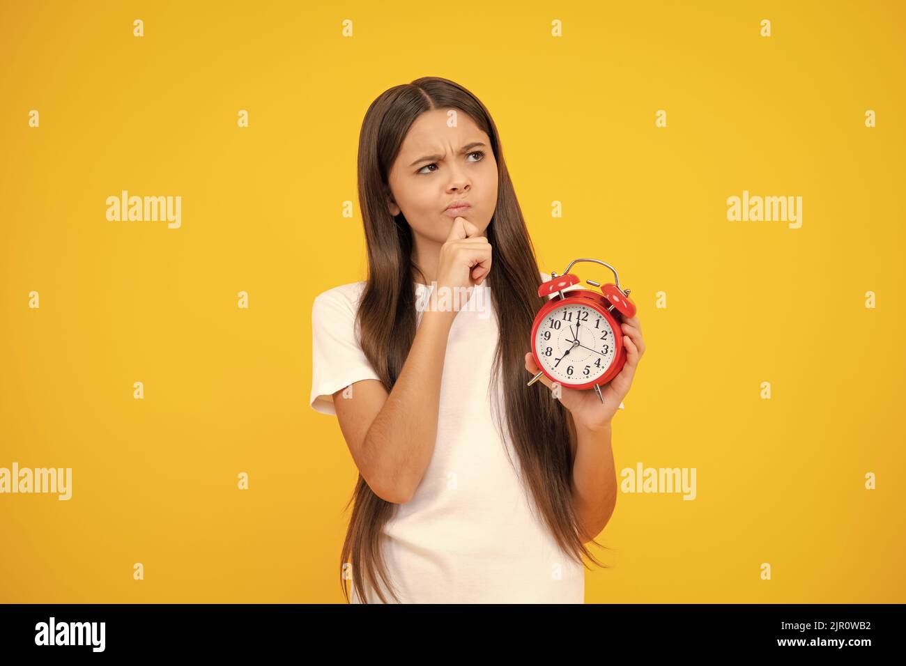 Child 12, 13, 14 years old look at alarm clock. Time for shopping sales ...