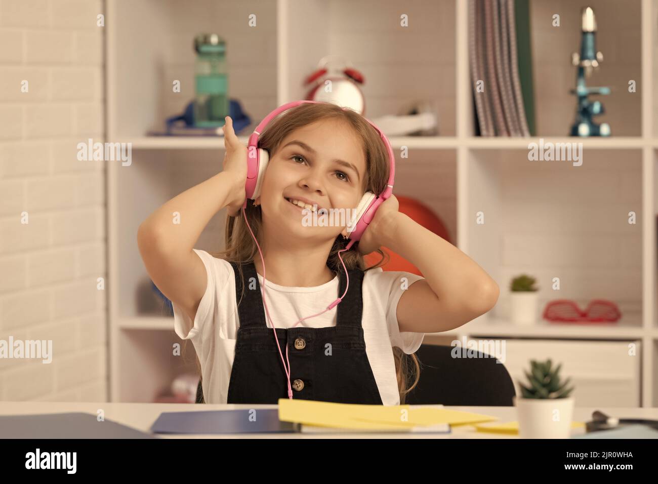 cheerful child listen to music in headphones at school classroom Stock ...