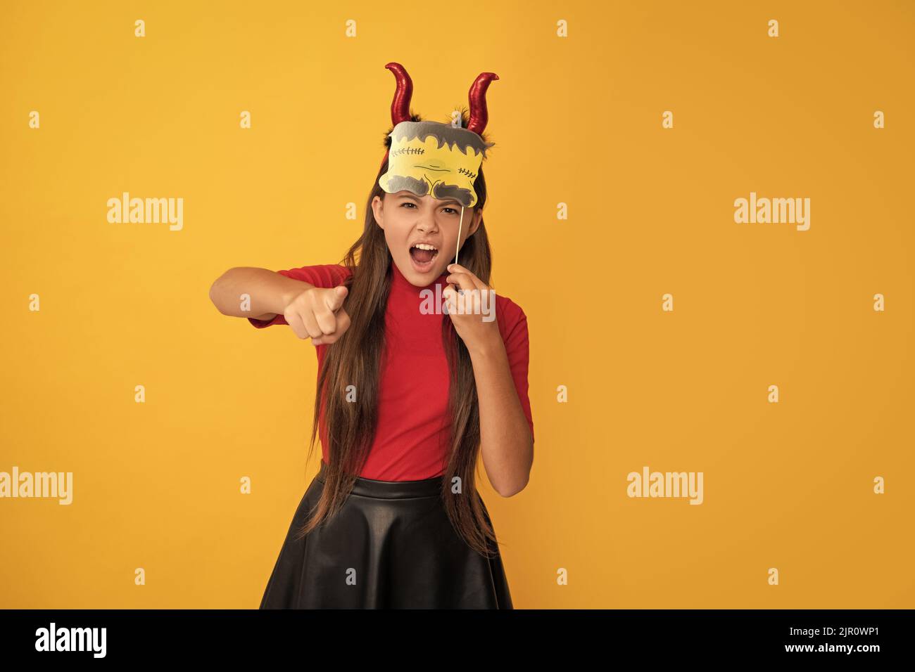 devil kid with pumpkin. trick or treat. teen girl point finger on ...