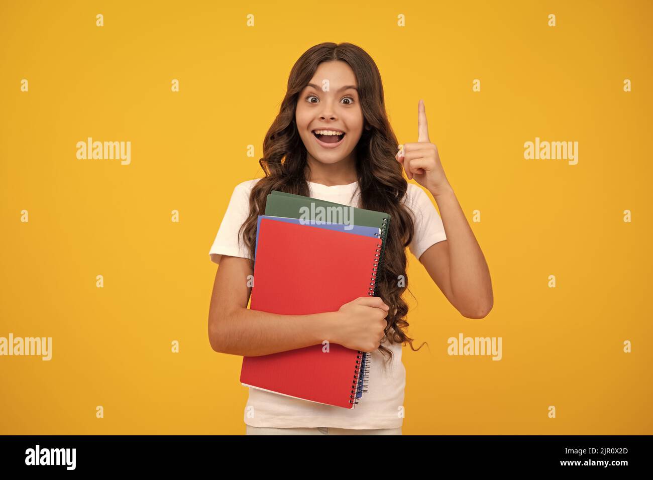 Amazed teen girl. Schoolgirl with copy book posing on isolated ...