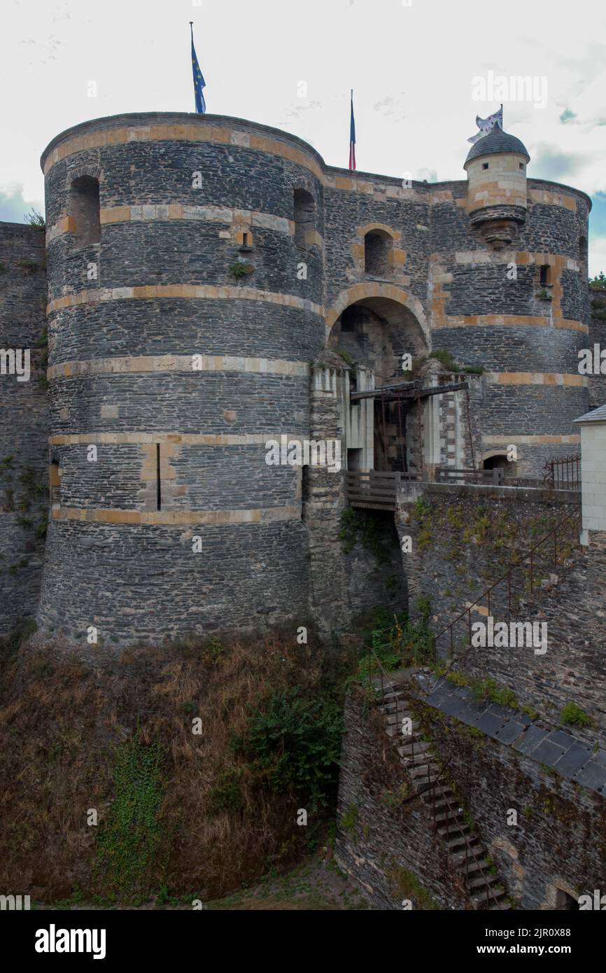 A vertical shot of the high towers and entrance of the Castle of Angers ...