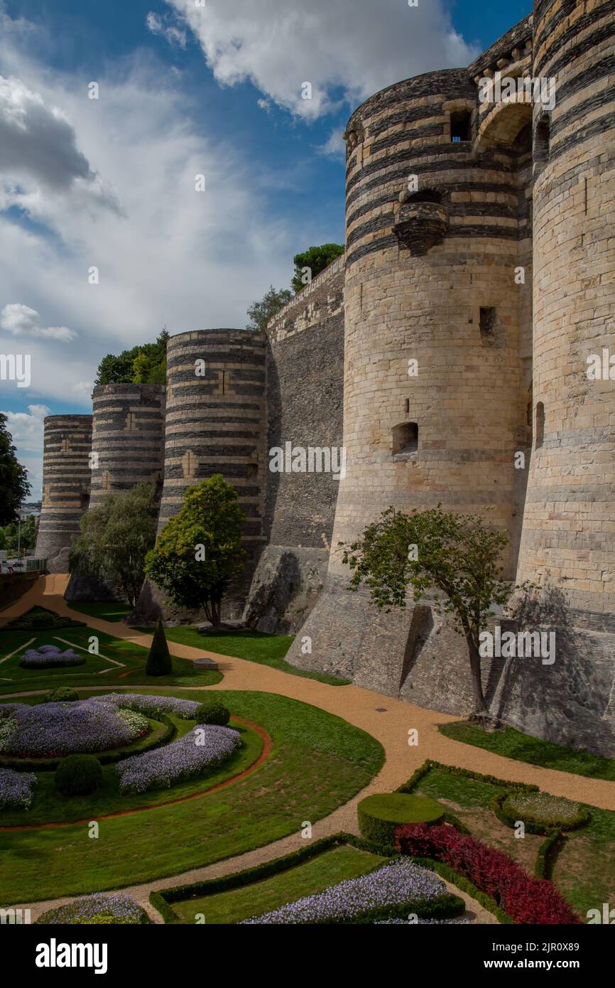 A vertical shot of the high towers and garden in the Castle of Angers ...