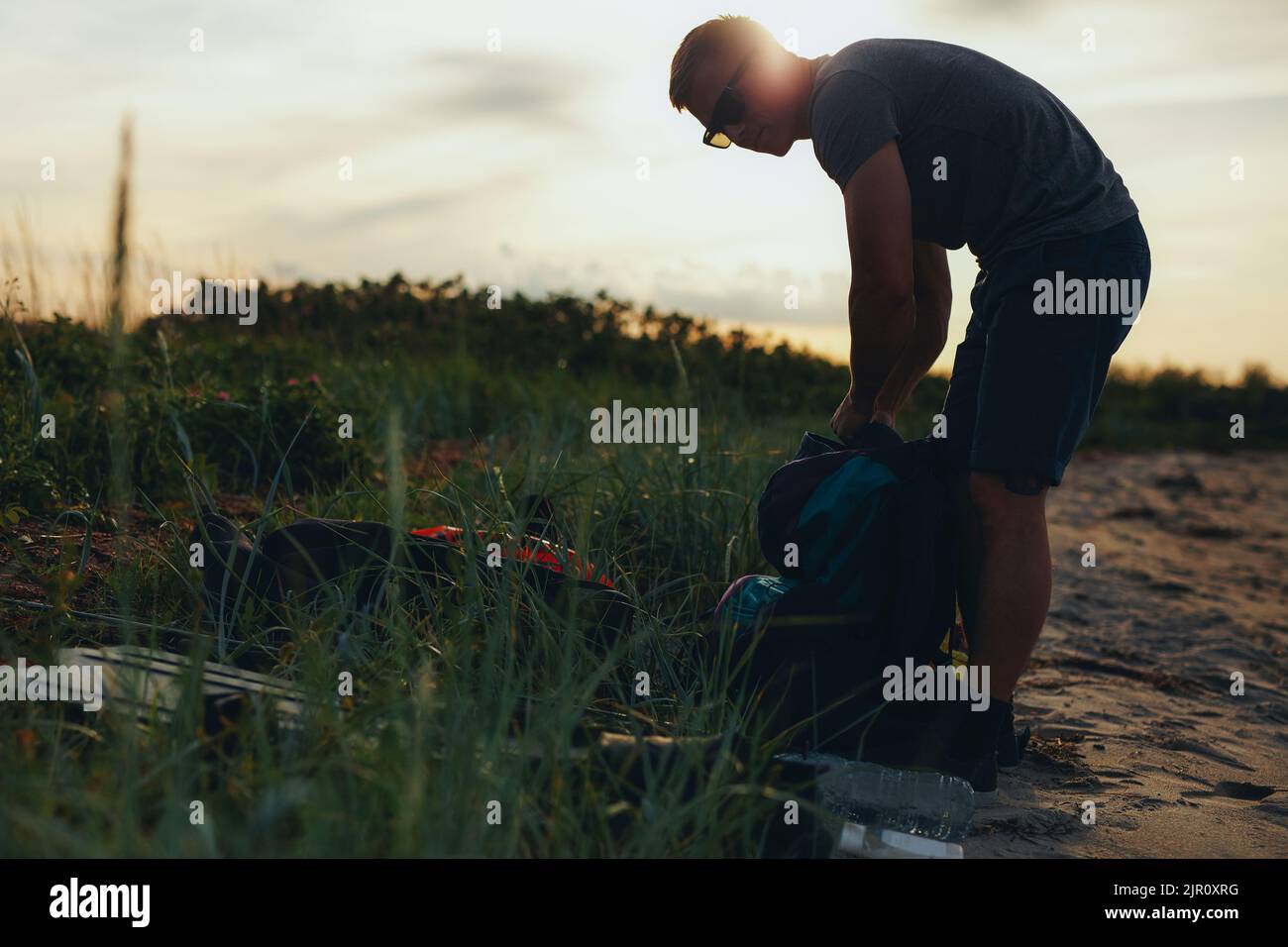 Young man taking out his spearfishing equipment from his bag ...