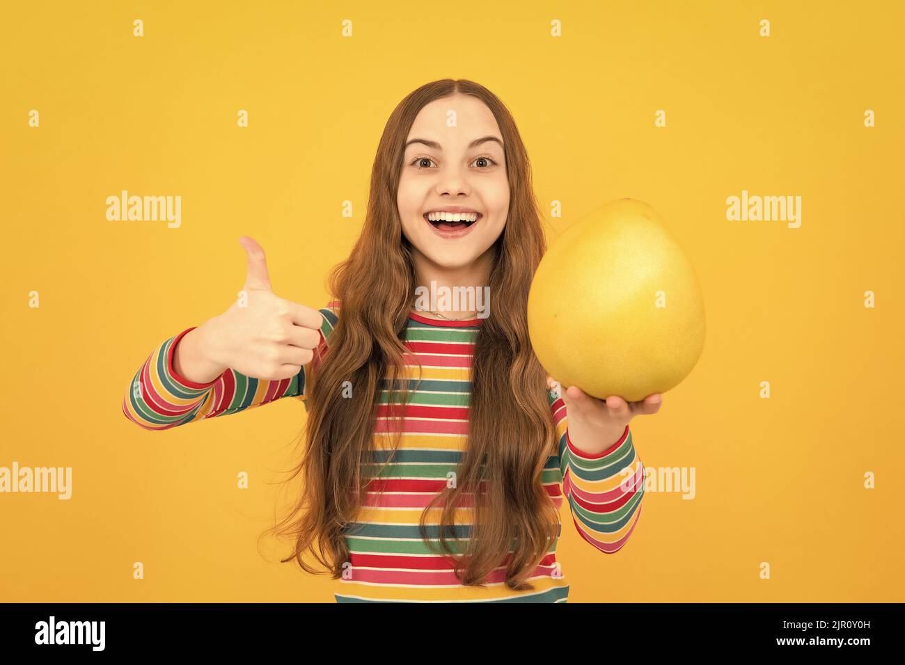 Summer fruits. Teenager child girl hold citrus fruit pummelo or pomelo ...