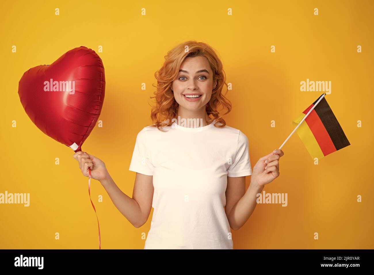Student woman holding German flag. Isolated on yellow background. Happy ...