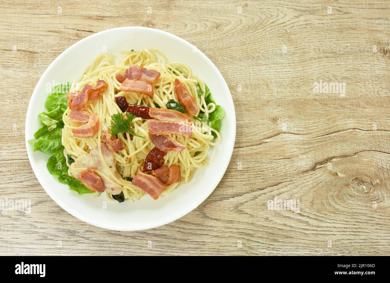 fried spaghetti topping crispy bacon and slice dry chili on plate Stock ...
