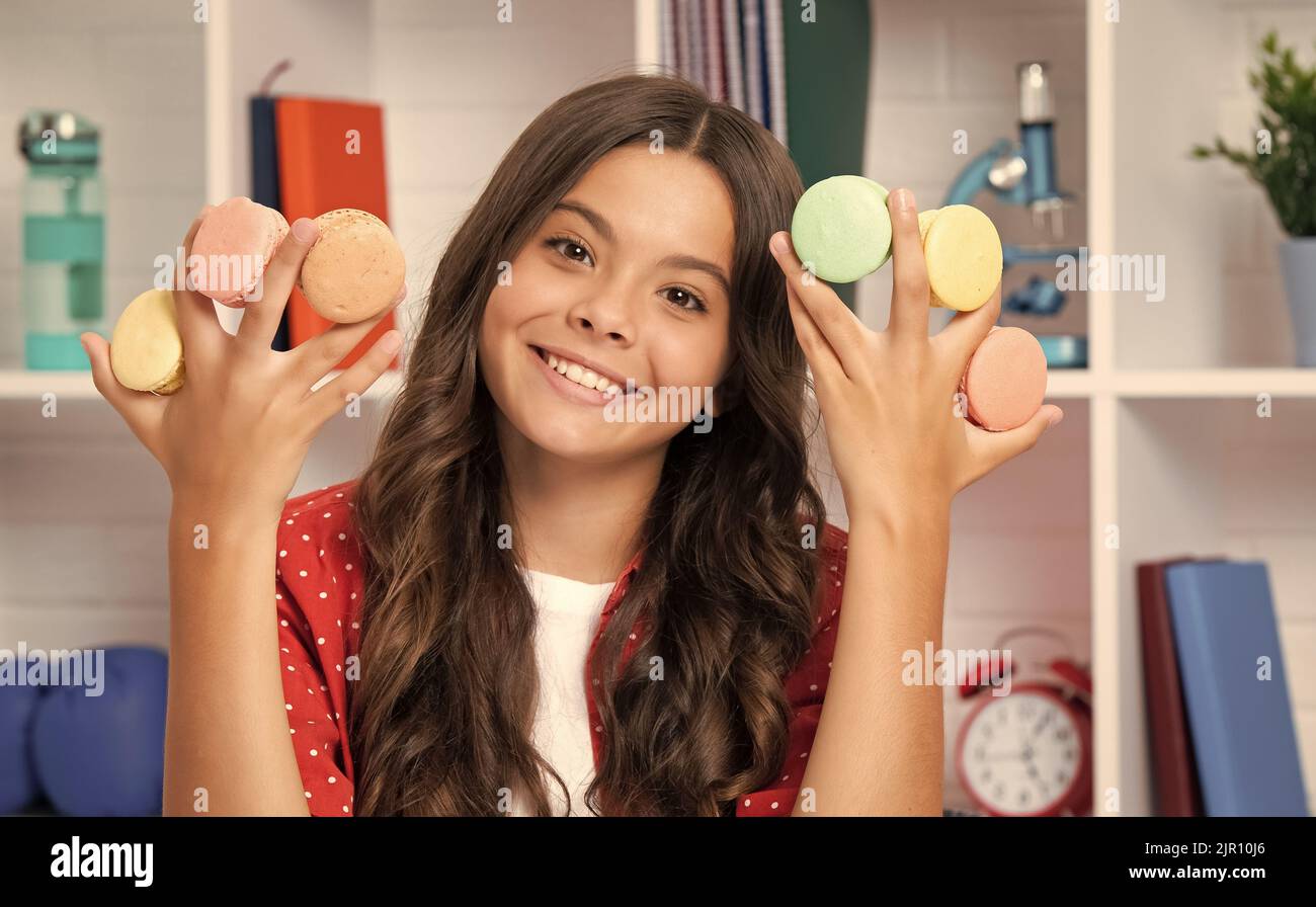 Child teen girl with dessert bakery. Teenager kid hold french macaron ...