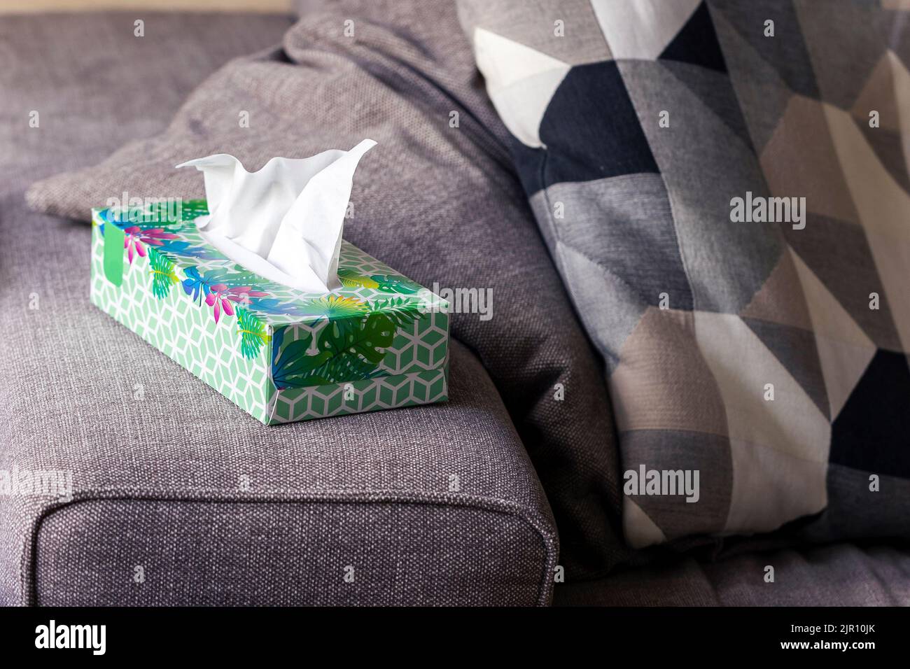 A portrait of a colorful box of paper tissues standing on the side of a ...
