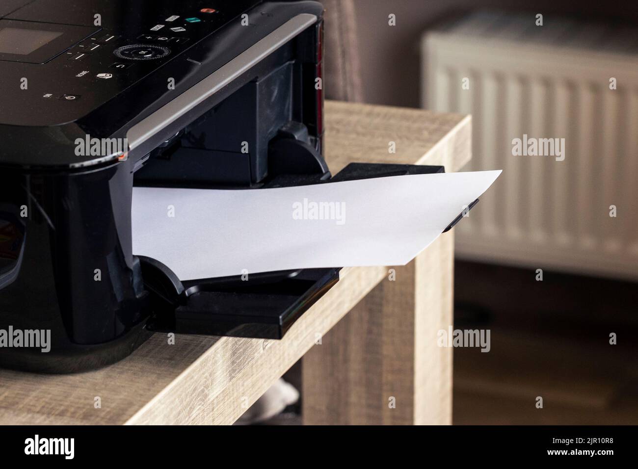 A portrait of a printer with an empty white piece of paper in its ...