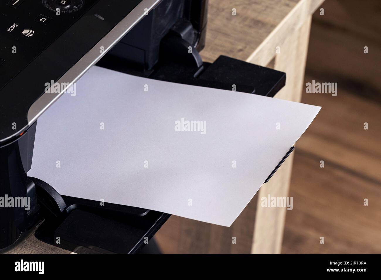 A close up portrait of a printer with an empty white piece of paper in ...