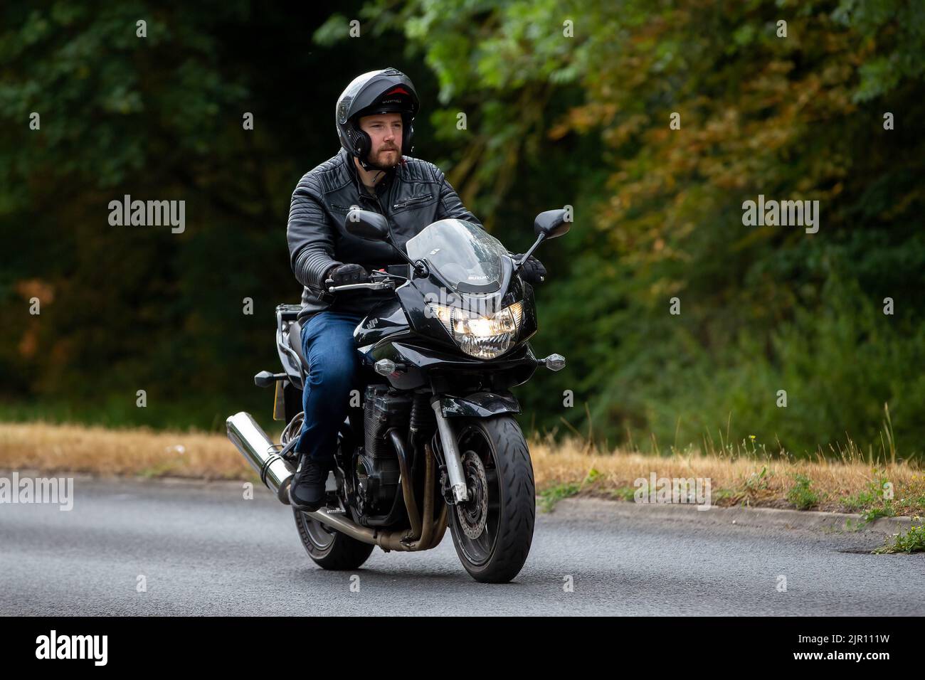 Man riding a black Suzuki motorcycle Stock Photo - Alamy