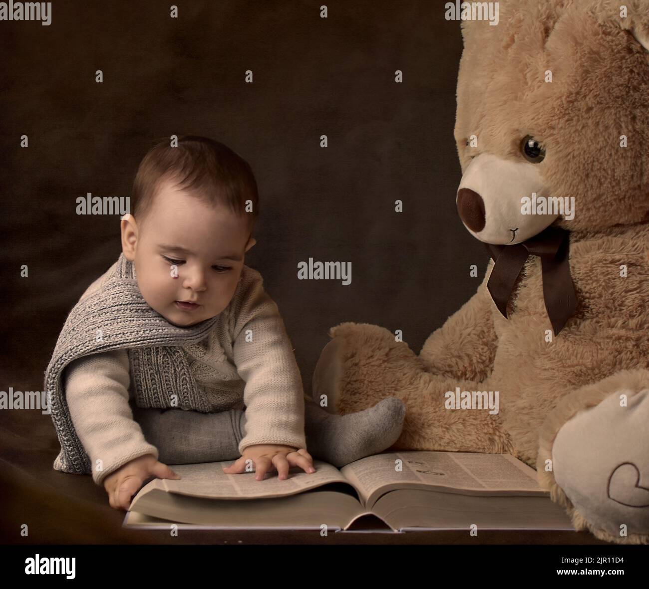 Inclusive baby wearing scarf reading a book for his Teddy bear ...