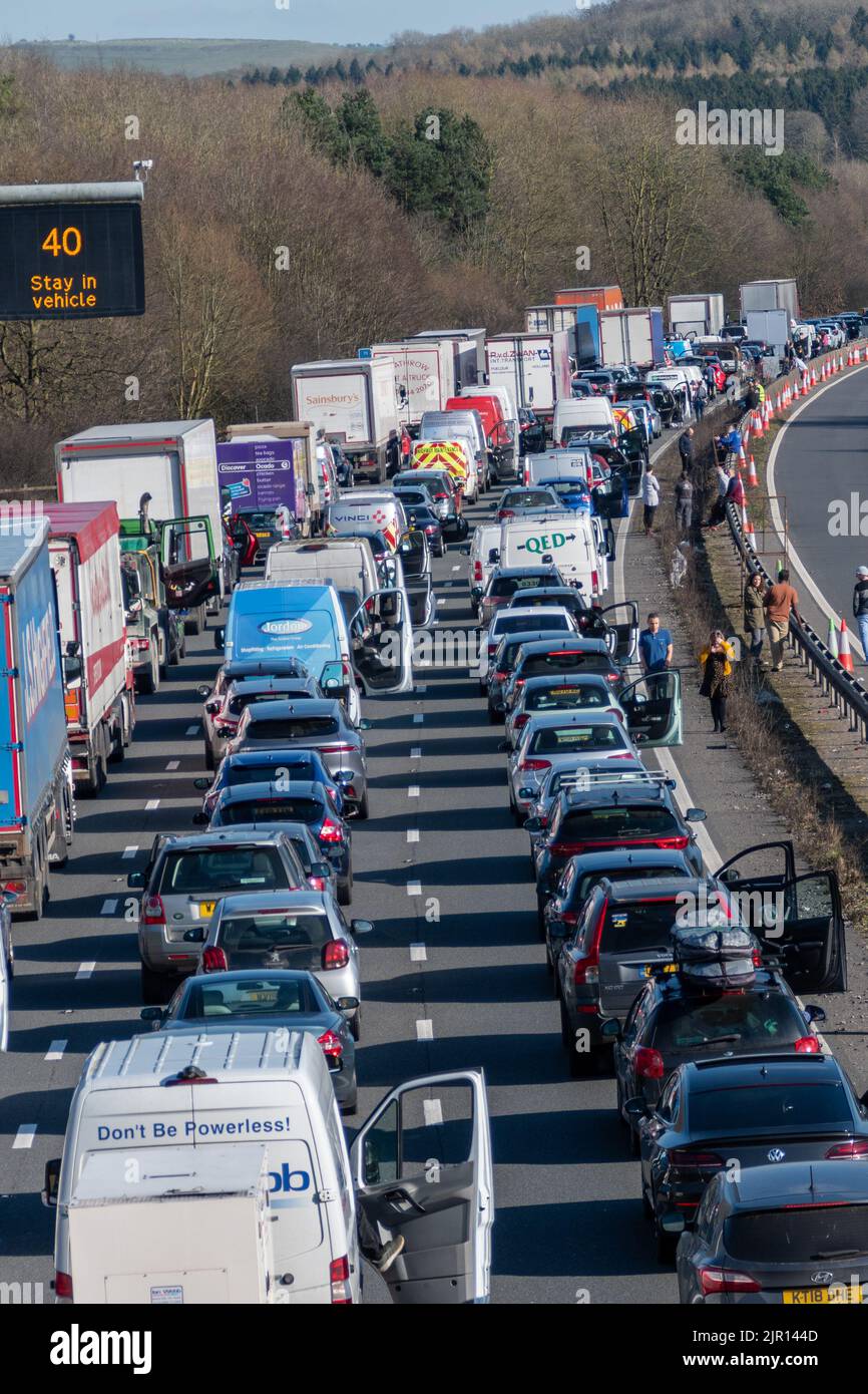 3 lanes of queued traffic on a British motorway with drivers out of ...