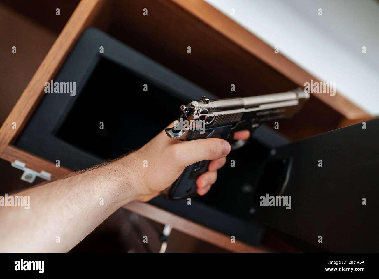Man takes the weapon from the safe Stock Photo - Alamy