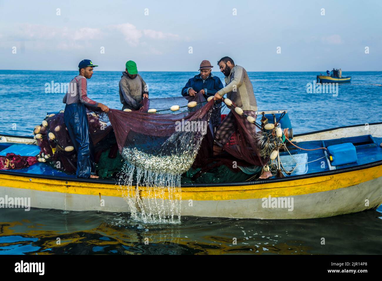 Gaza, Palestine A group of fishermen collecting abundant fishing nets ...