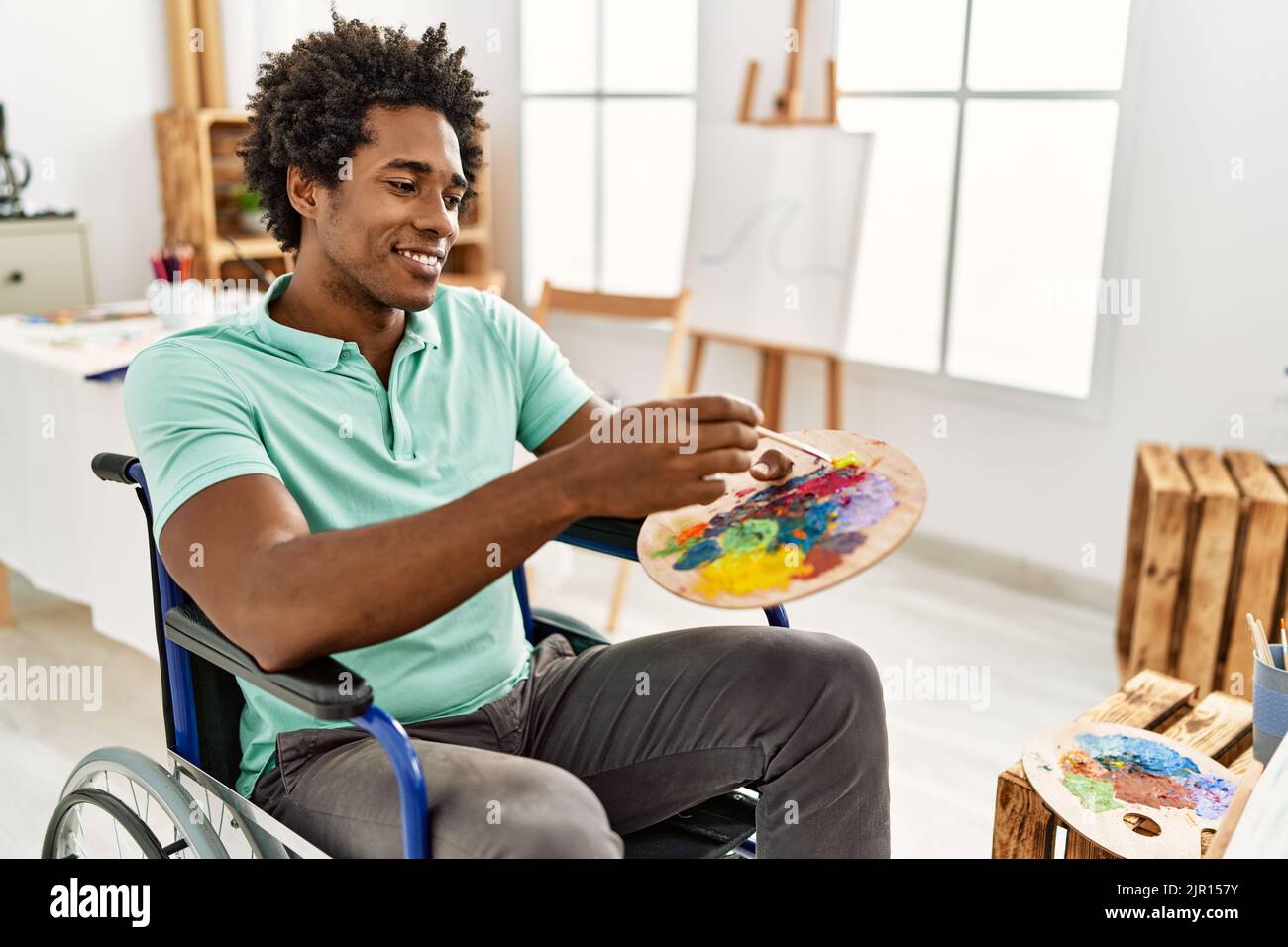 Young african american disabled artist man sitting on wheelchair ...