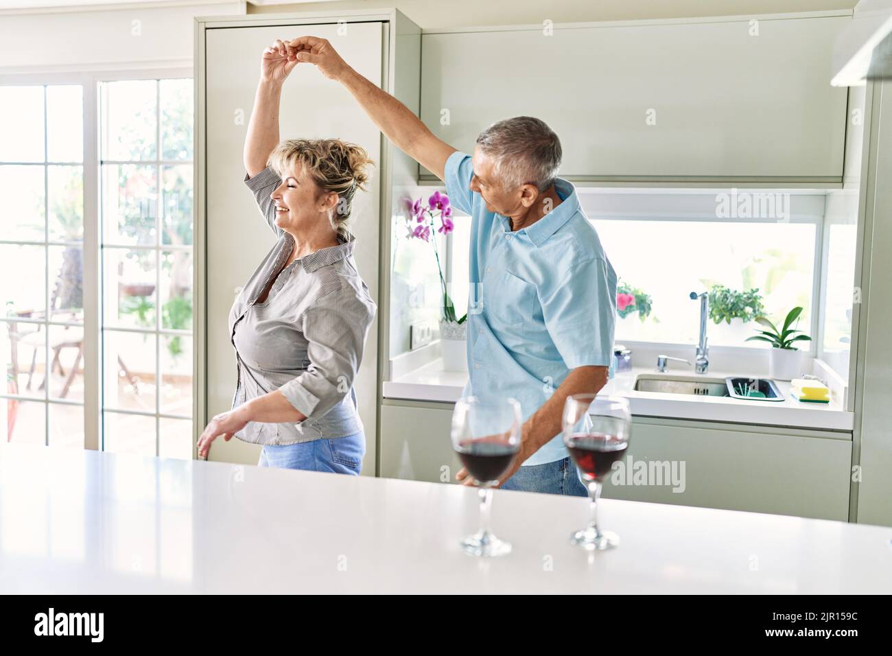 Senior caucasian couple smiling happy dancing at the kitchen Stock ...