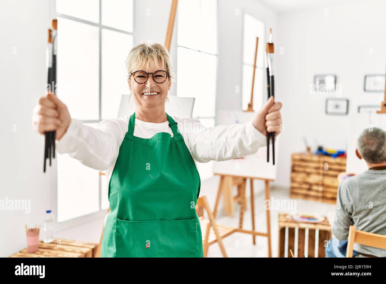Two senior paint student smiling happy painting at art studio. Woman ...