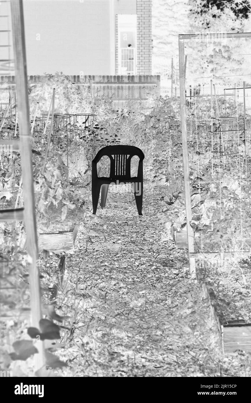Typical single plastic chair standing empty in the overgrown late ...