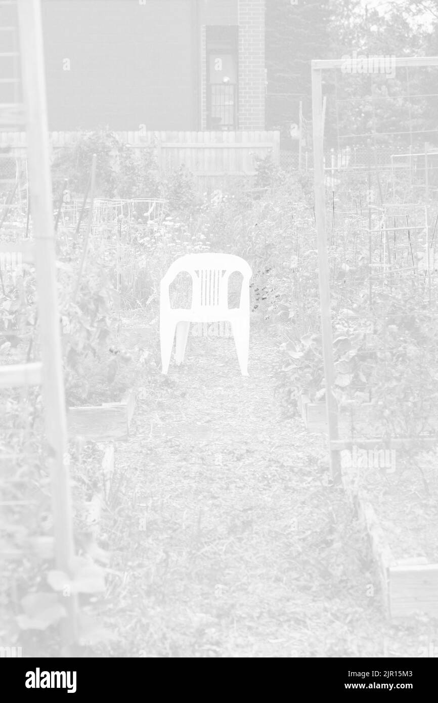 Typical single plastic chair standing empty in the overgrown late ...