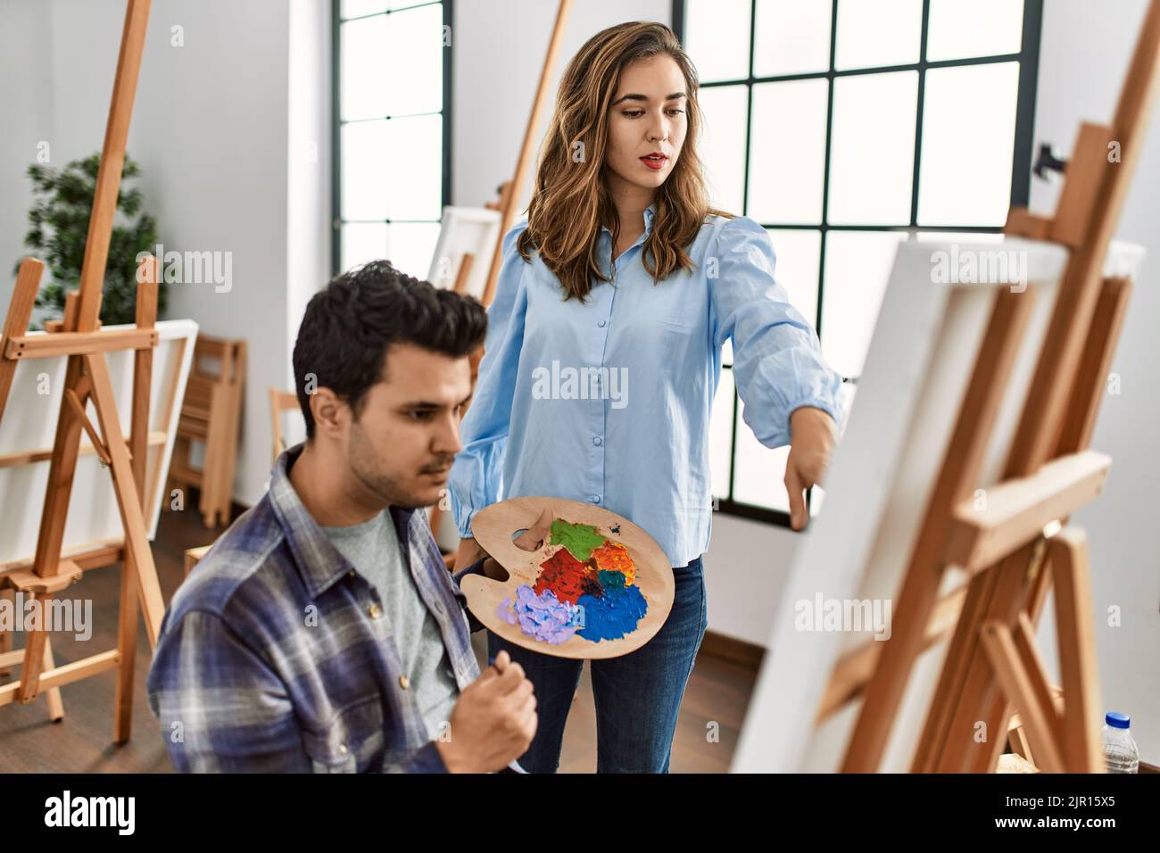 Paint teacher teaching to student at art school Stock Photo - Alamy
