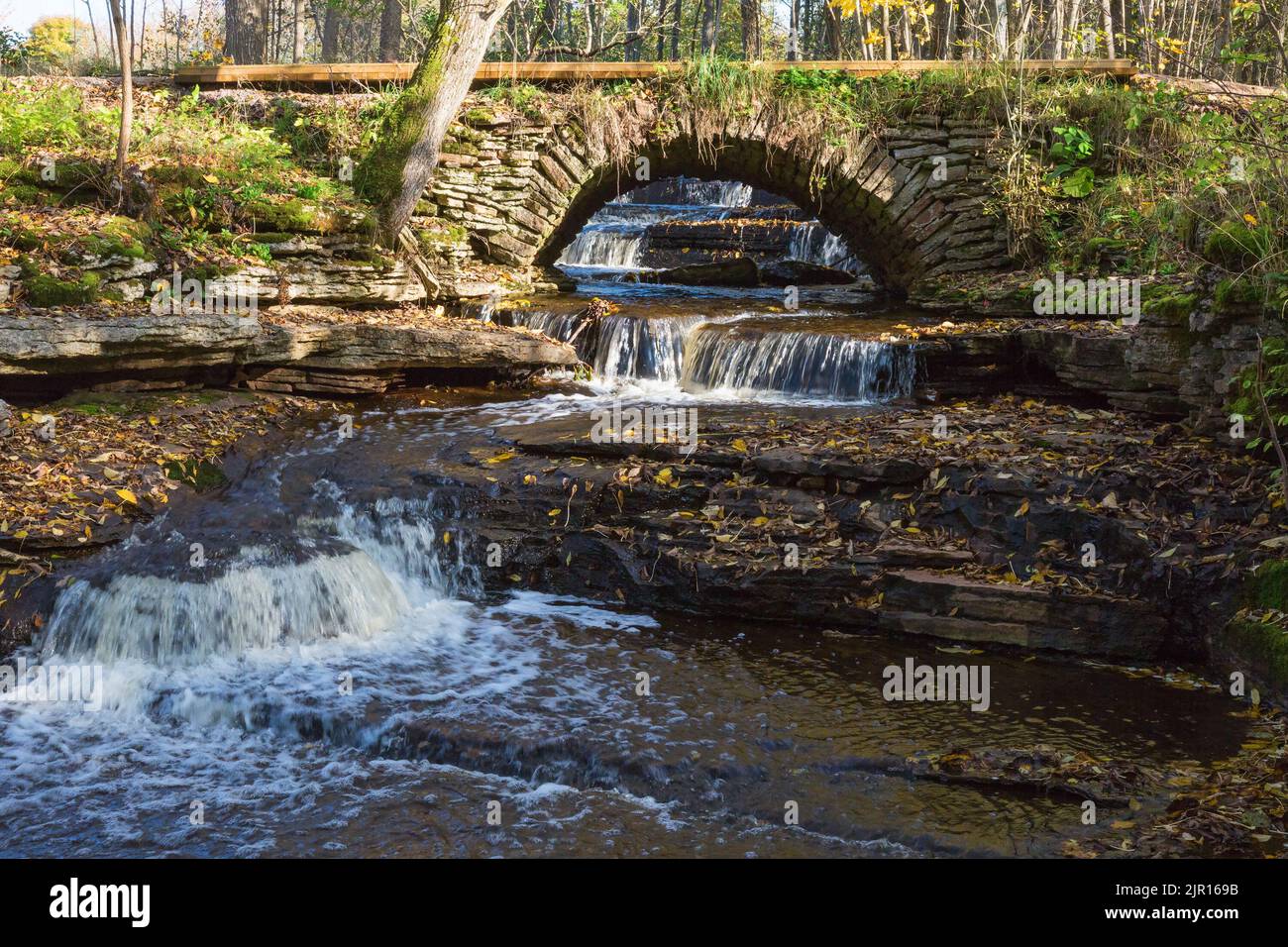 Old arch bridge a creek with waterfalls Stock Photo - Alamy