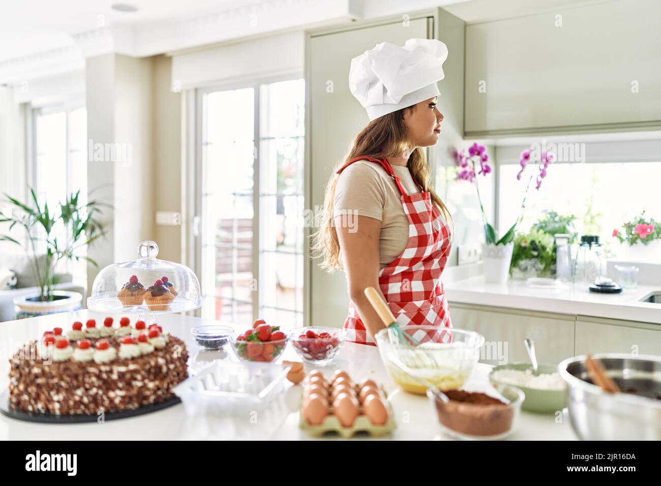 Beautiful young brunette pastry chef woman cooking pastries at the ...