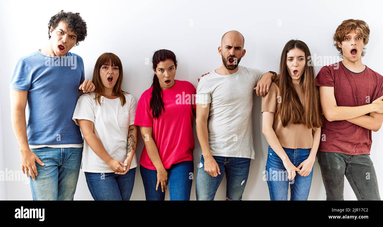 Group of young friends standing together over isolated background in ...