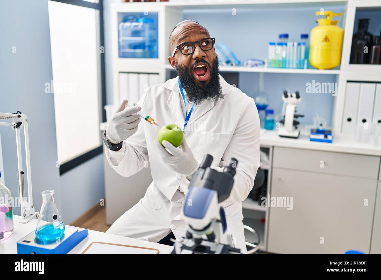 African american man working at scientist laboratory with apple angry ...