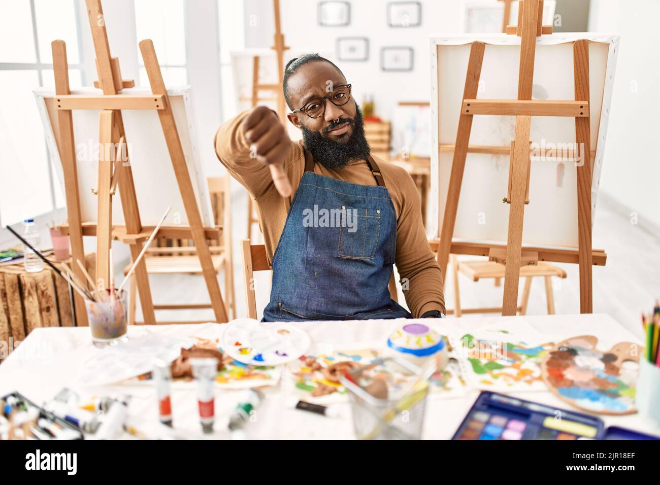 African american artist man at art studio looking unhappy and angry ...