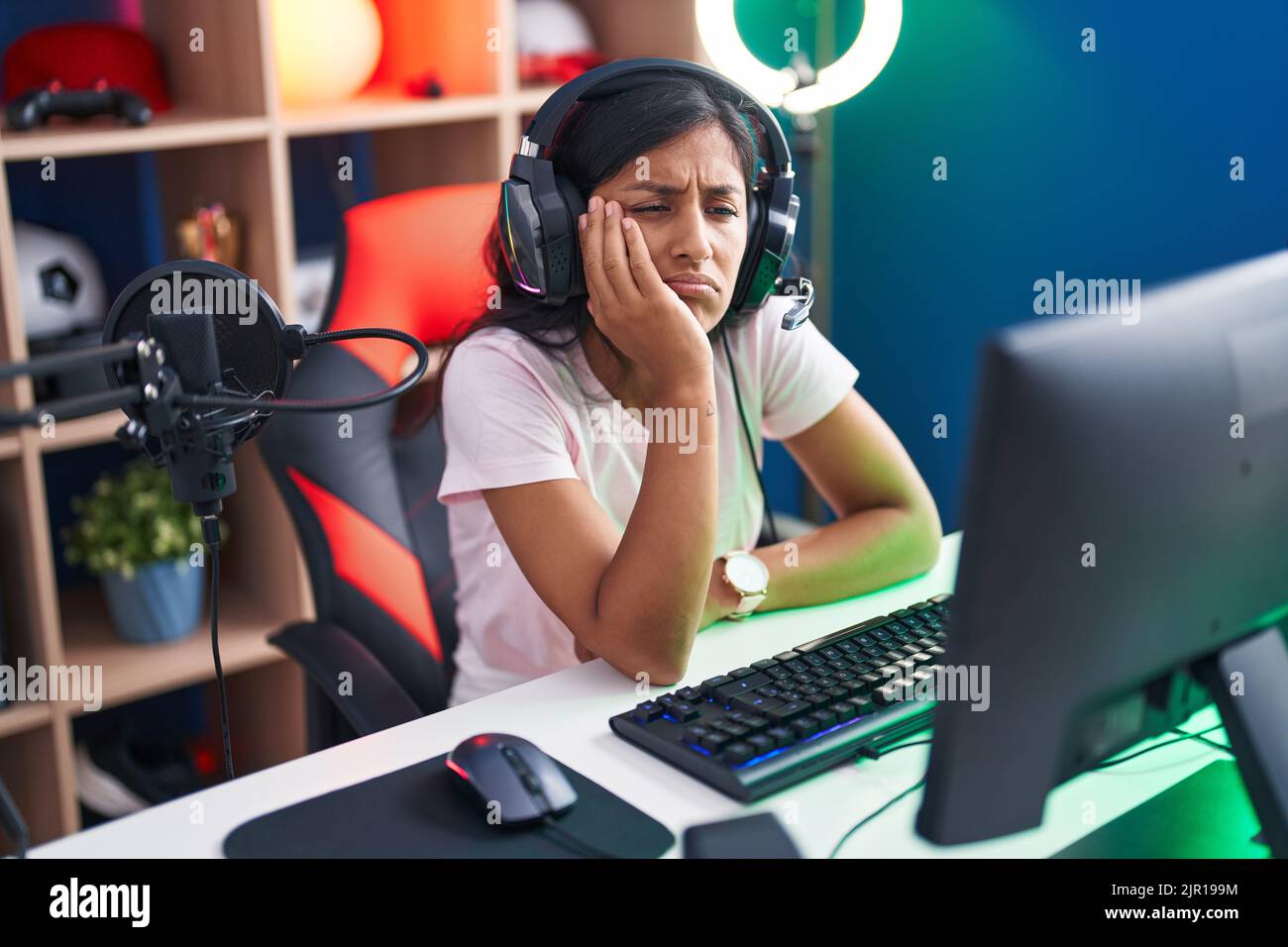 Young beautiful hispanic woman streamer stressed using computer at ...
