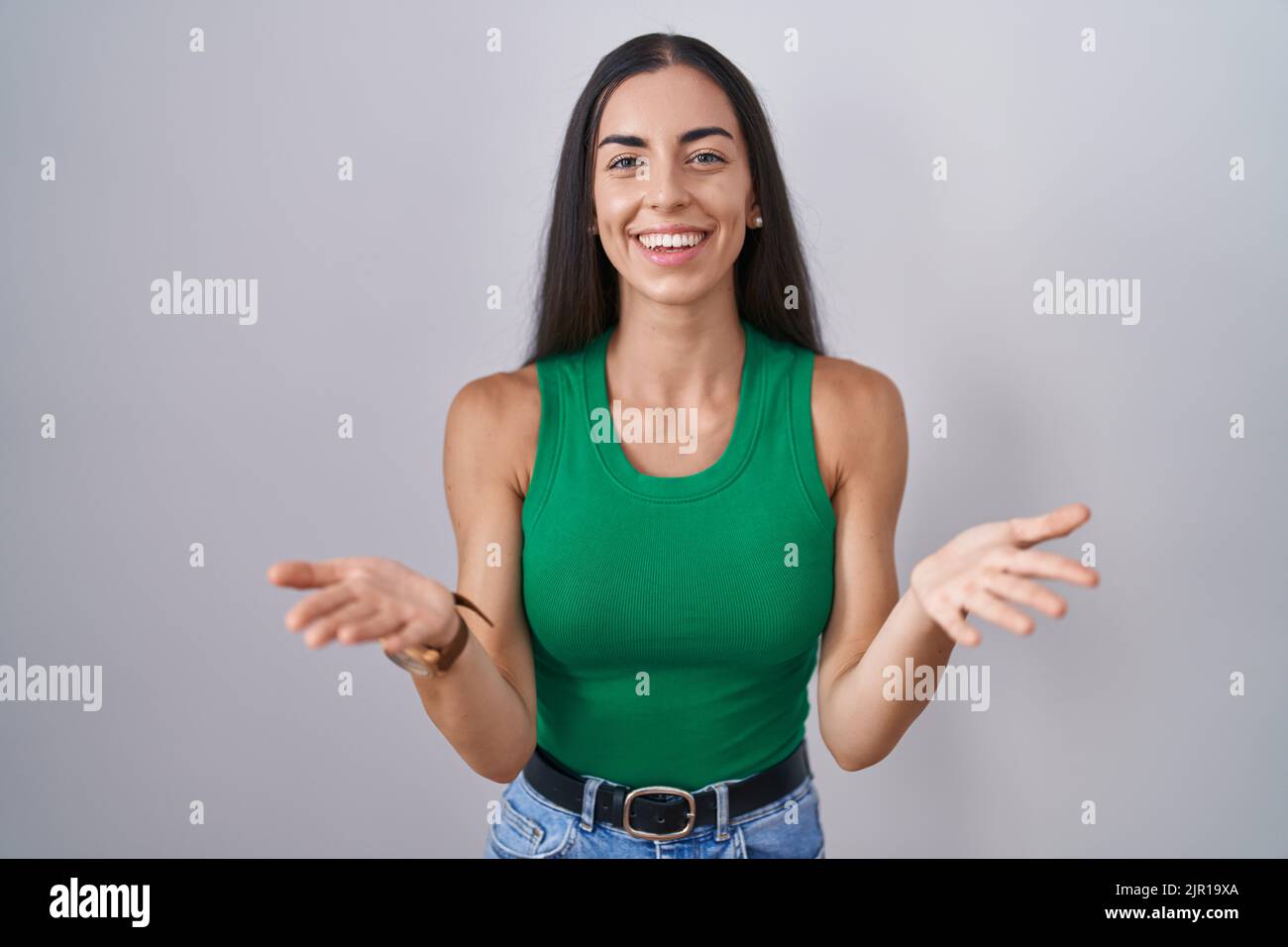 Young woman standing over isolated background smiling cheerful offering ...