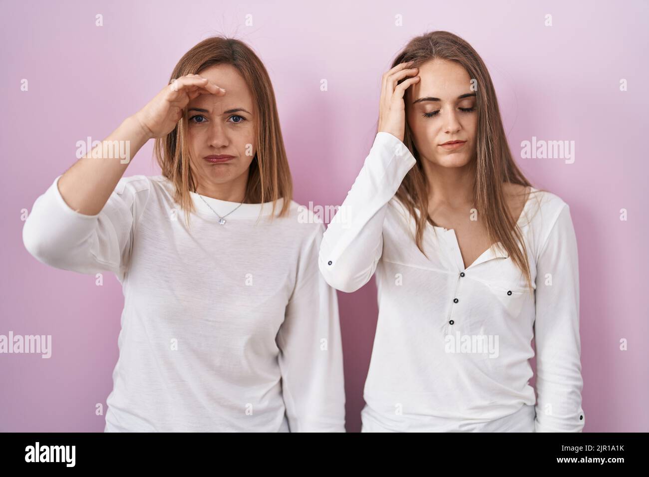 Middle Age Mother And Young Daughter Standing Over Pink Background