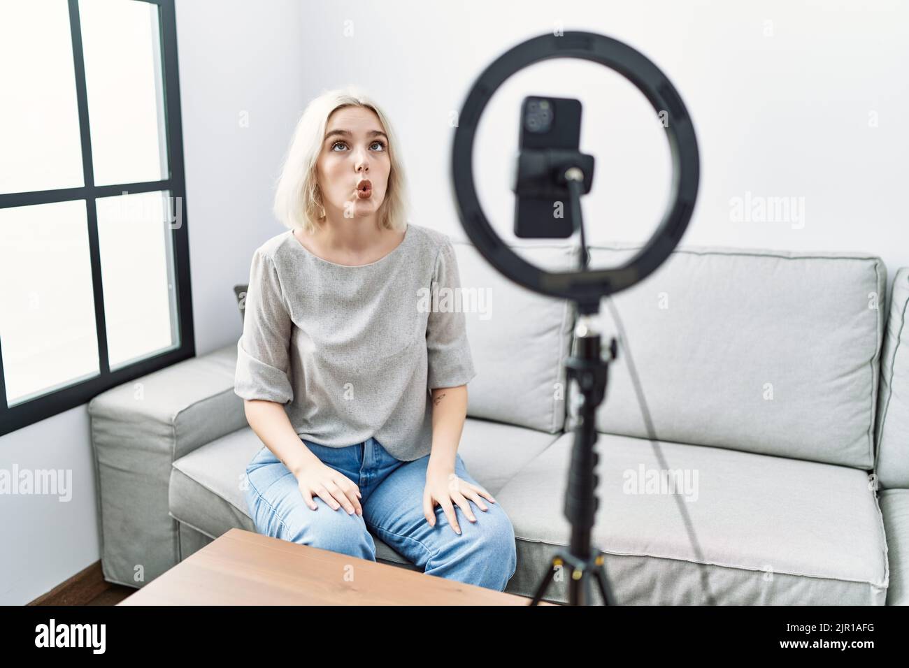 Young caucasian woman recording vlog tutorial with smartphone at home ...