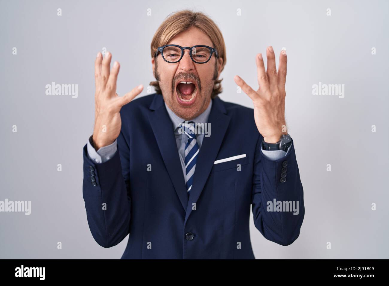 Caucasian man with mustache wearing business clothes celebrating mad and crazy for success with ...