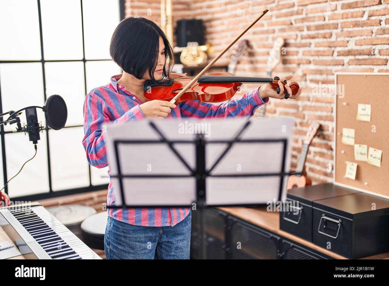 Young chinese woman musician playing violin at music studio Stock Photo ...