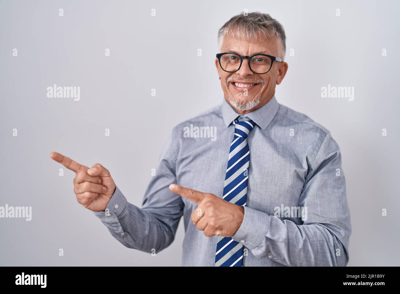 Hispanic business man with grey hair wearing glasses smiling and ...