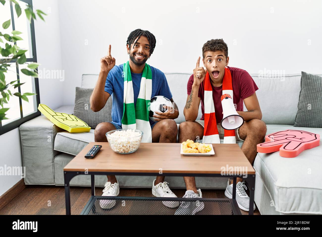 Young hispanic brothers football hooligans holding ball and megaphone ...