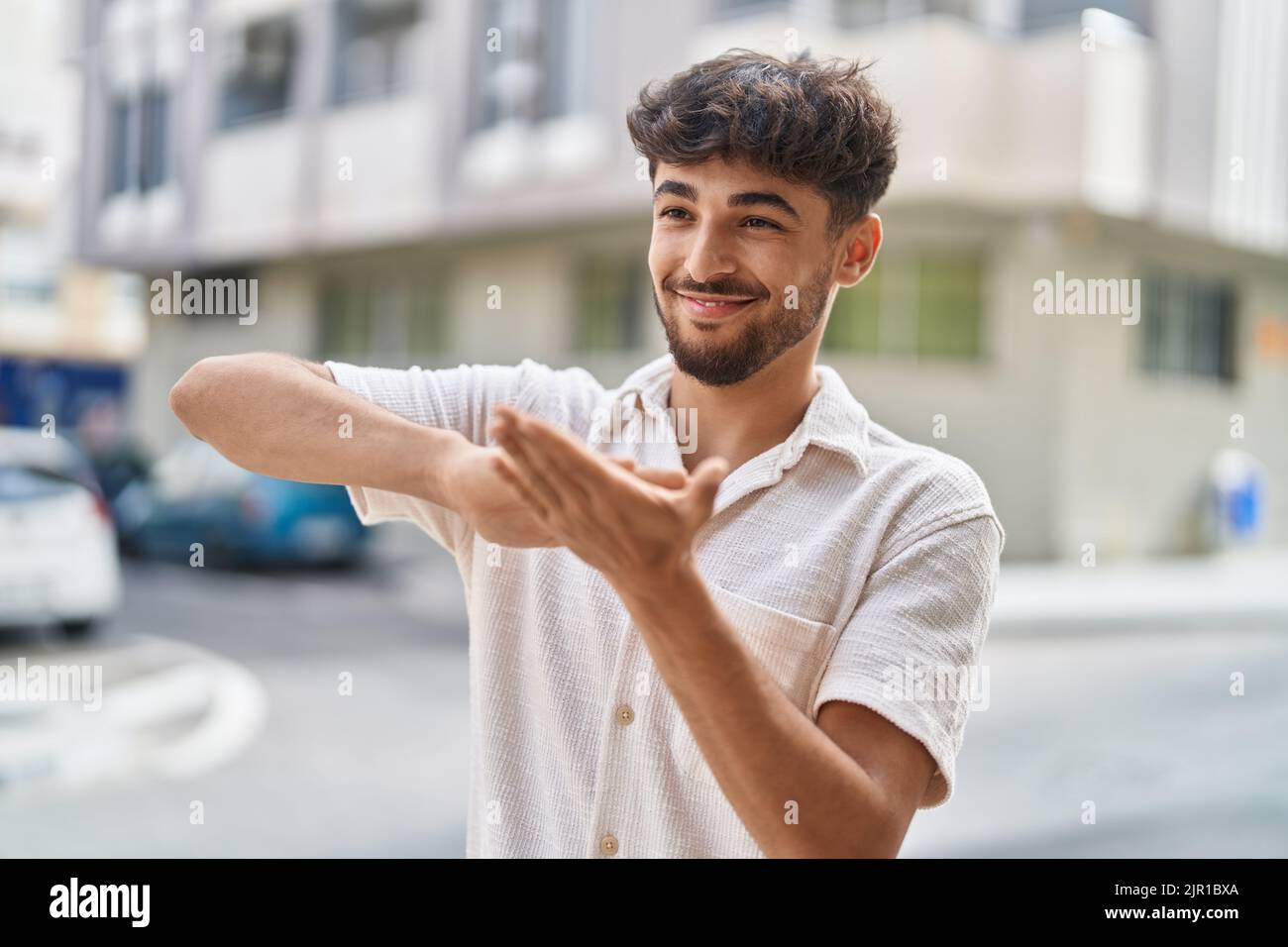 Young arab man smiling confident doing spend money gesture at street ...