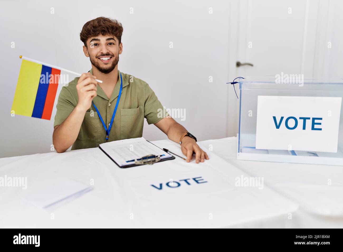 Young arab man smiling confident holding colombia flag working at ...