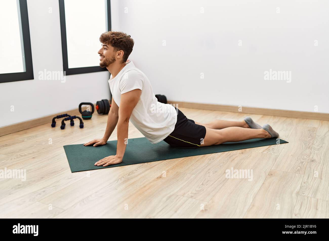 Young arab man smiling confident stretching at sport center Stock Photo ...