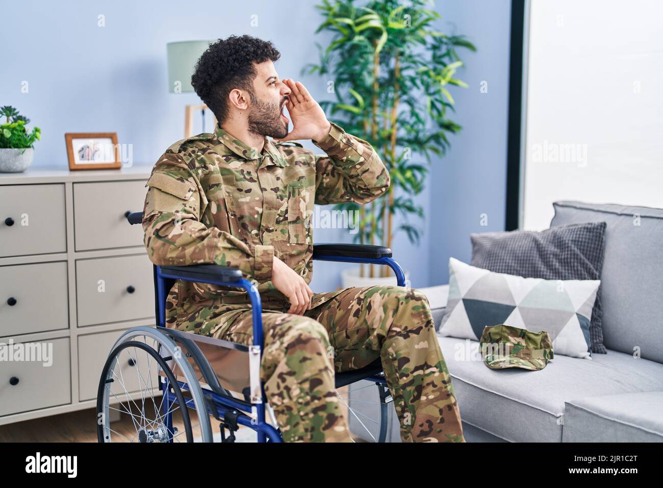 Arab man wearing camouflage army uniform sitting on wheelchair shouting ...