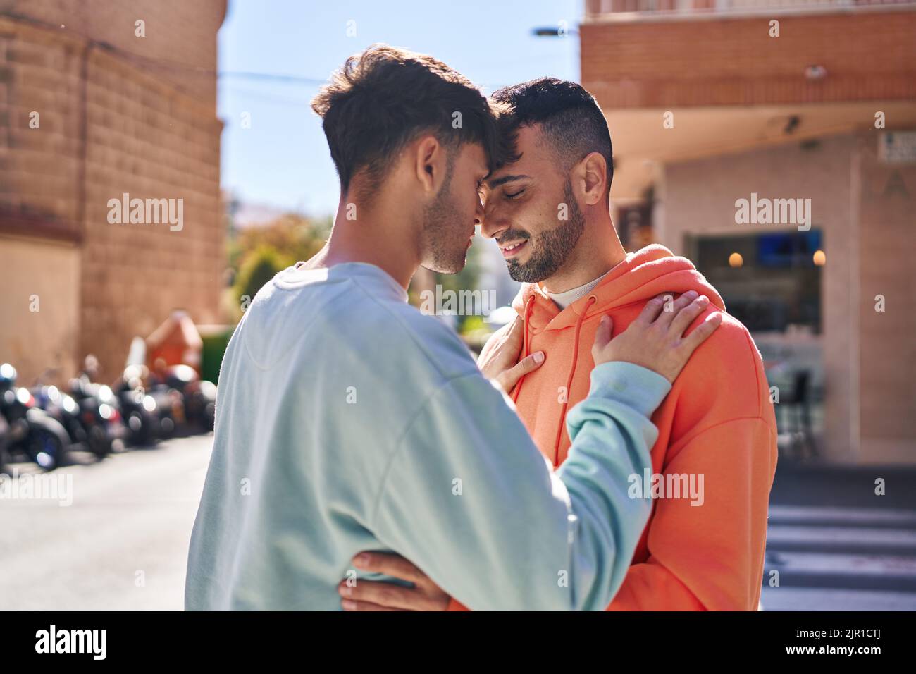 Two man couple hugging each other standing at street Stock Photo - Alamy