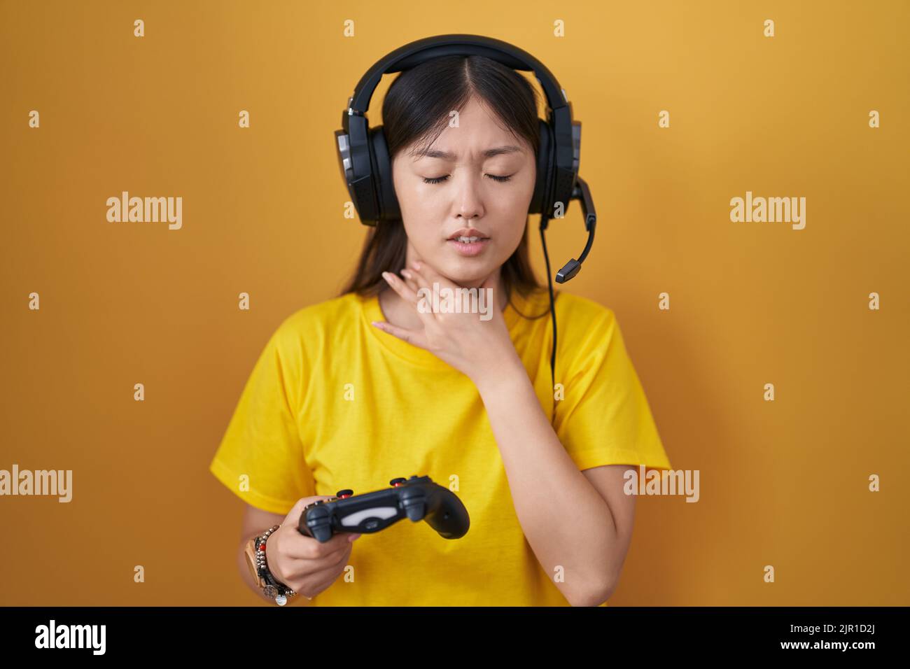 Chinese young woman playing video game holding controller touching ...