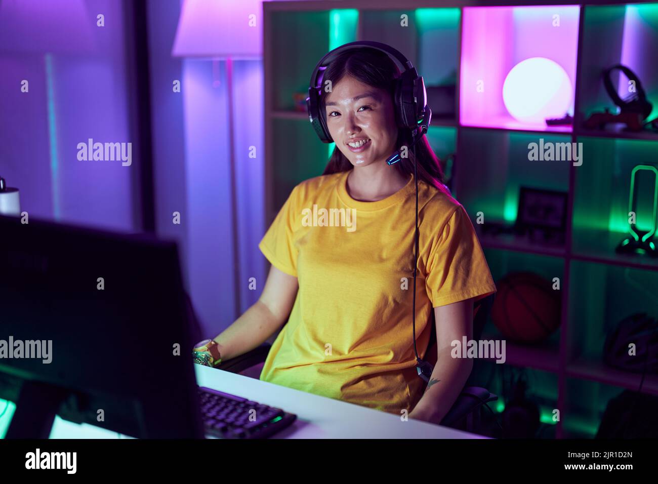 Chinese woman streamer smiling confident using computer at gaming room ...