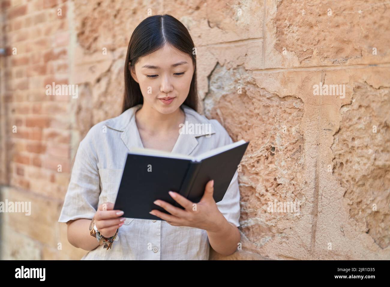 Chinese woman reading book at street Stock Photo - Alamy