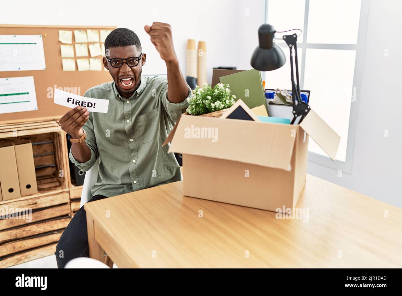 Young african american businessman holding fired banner at the office ...